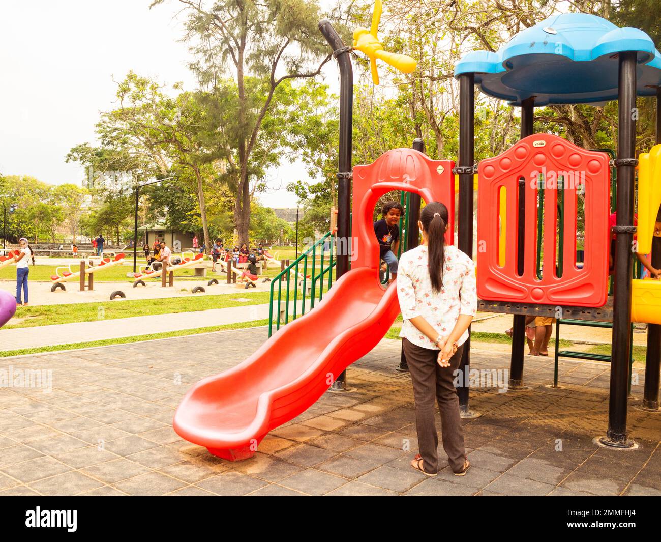 baby boy playing with slide and mother keep watching for safety Stock ...