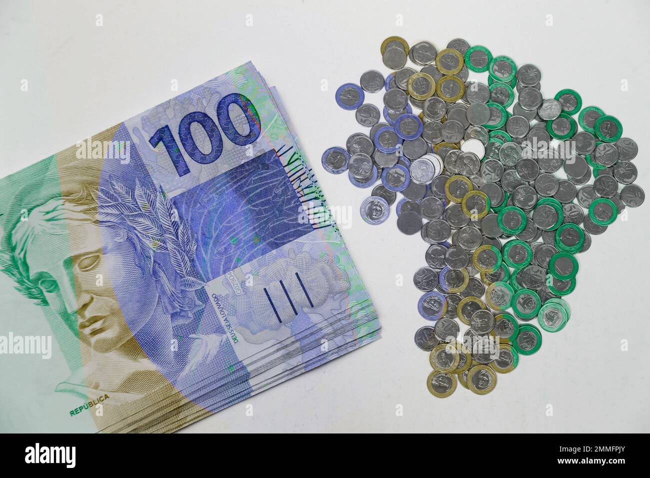 several hundred reais notes and coins from Brazil on neutral white ...