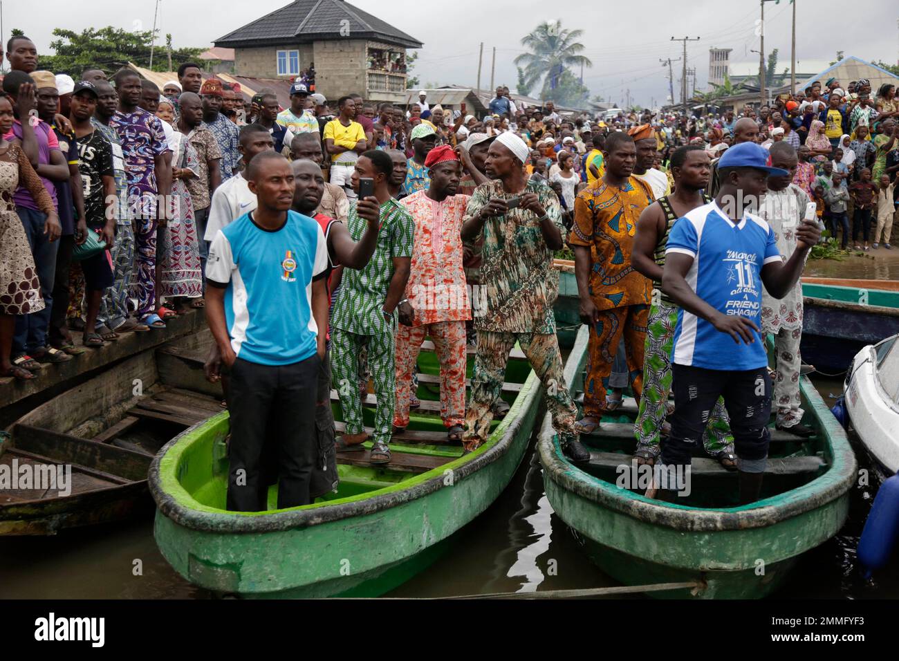 People watch masquerade known as Zangbeto during a regatta to mark ...