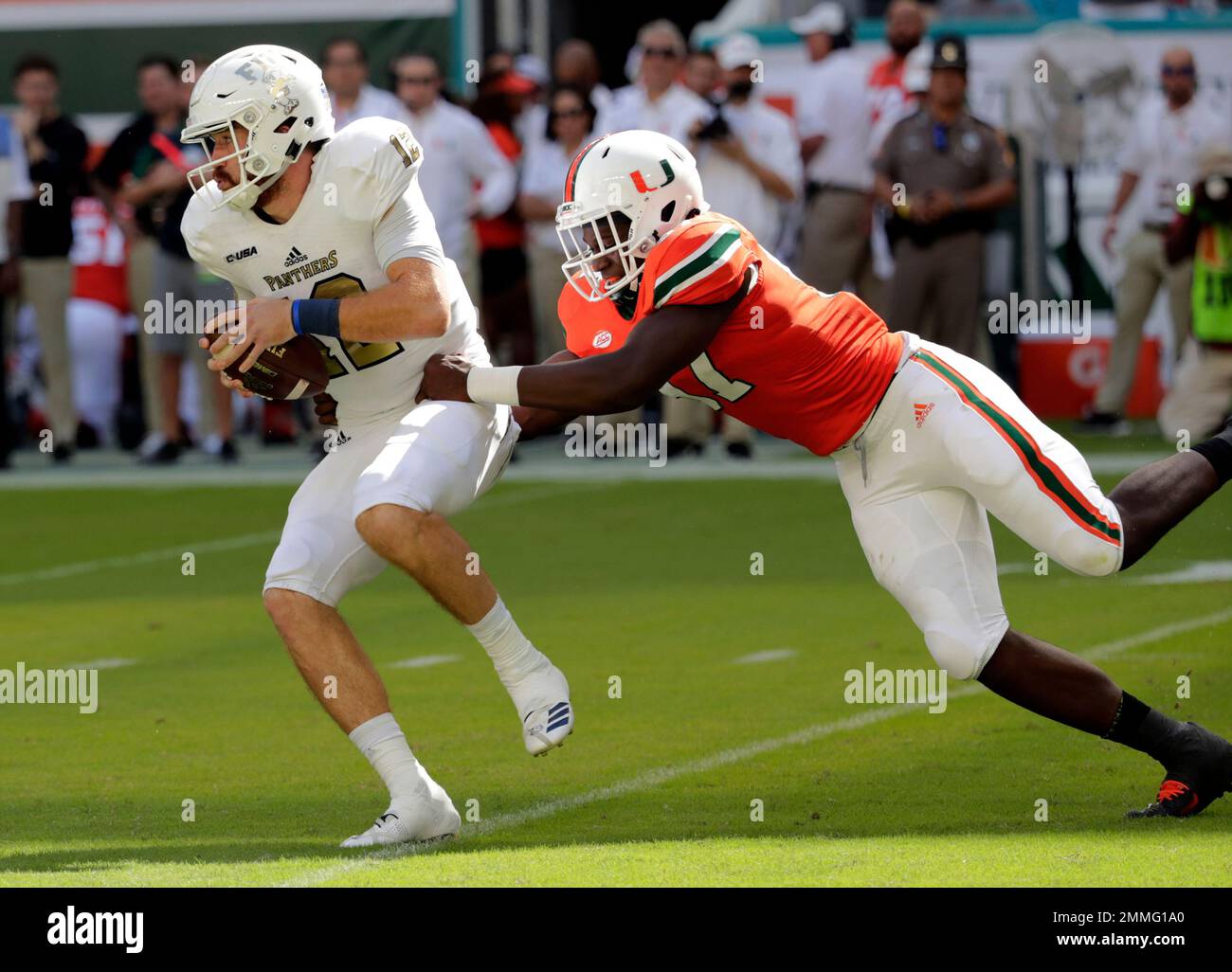 FIU quarterback James Morgan, left, is pressured by Miami defensive ...
