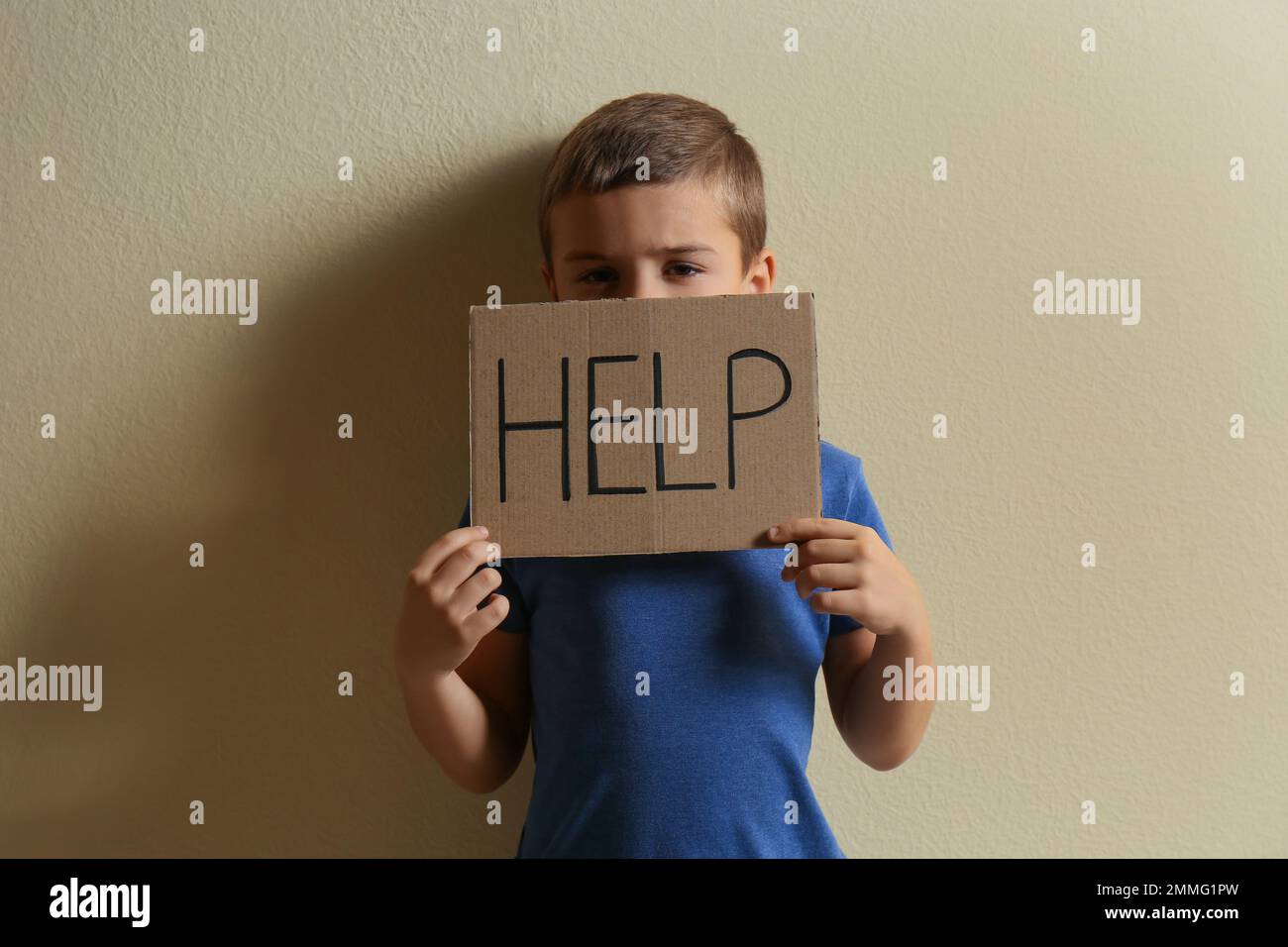 Little boy with sign HELP on yellow background. Child in danger Stock ...