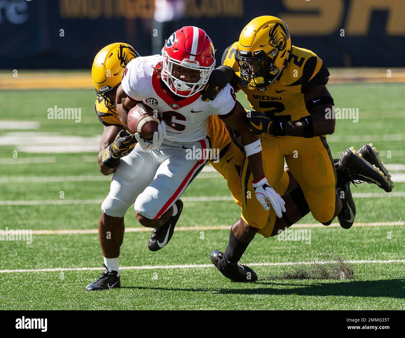 Georgia running back James Cook, center, is tackled by Missouri's ...