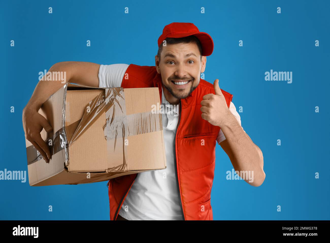 Emotional courier with damaged cardboard box on blue background. Poor ...