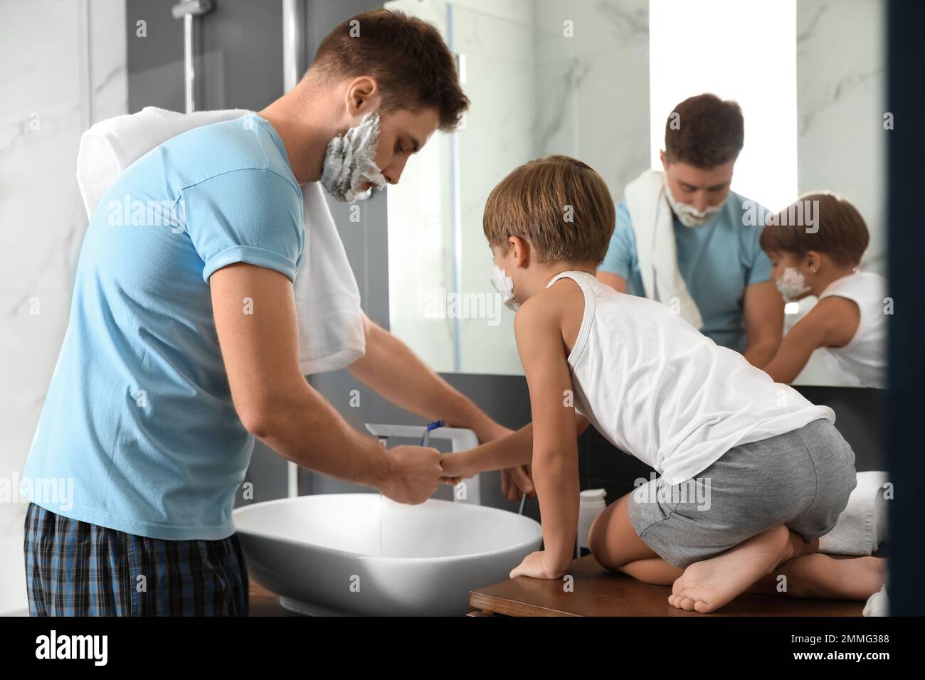 Dad and son washing razors in bathroom Stock Photo - Alamy