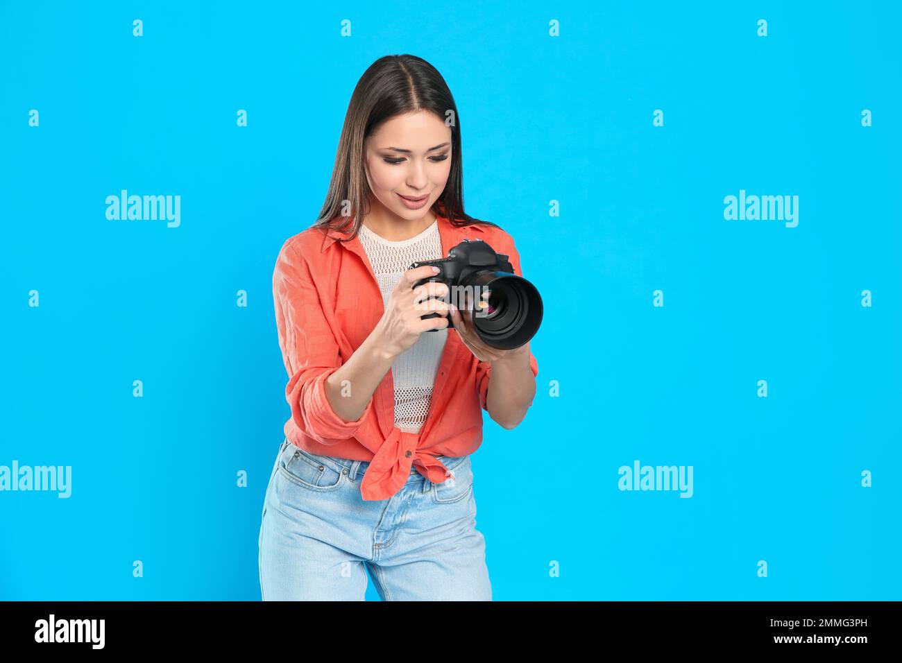 Professional photographer working on light blue background in studio ...