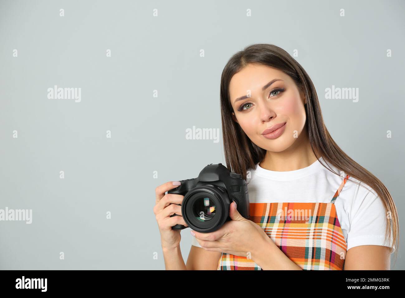 Professional photographer working on light grey background in studio ...