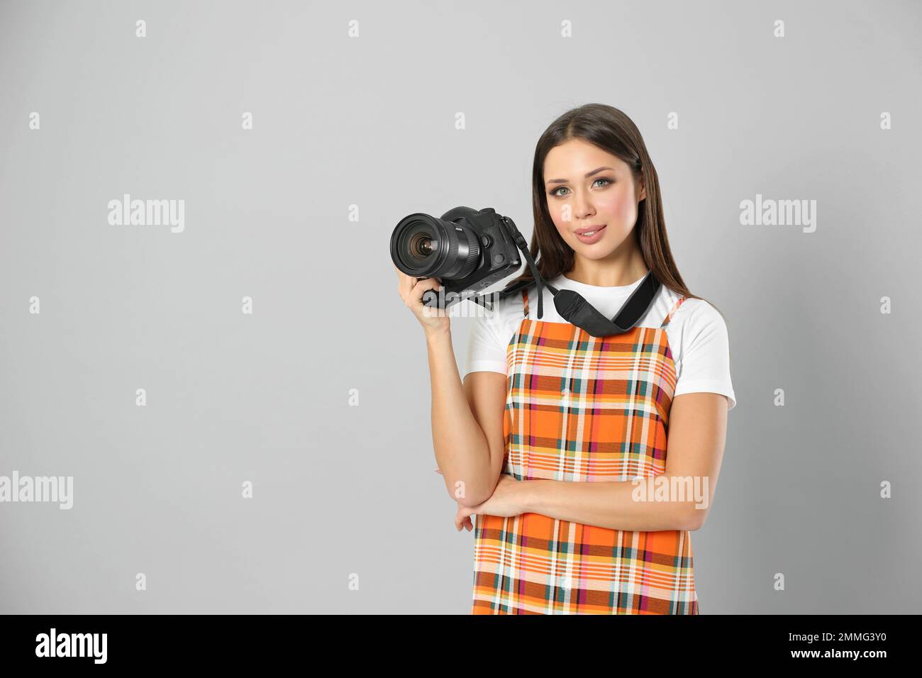 Professional photographer working on light grey background in studio ...