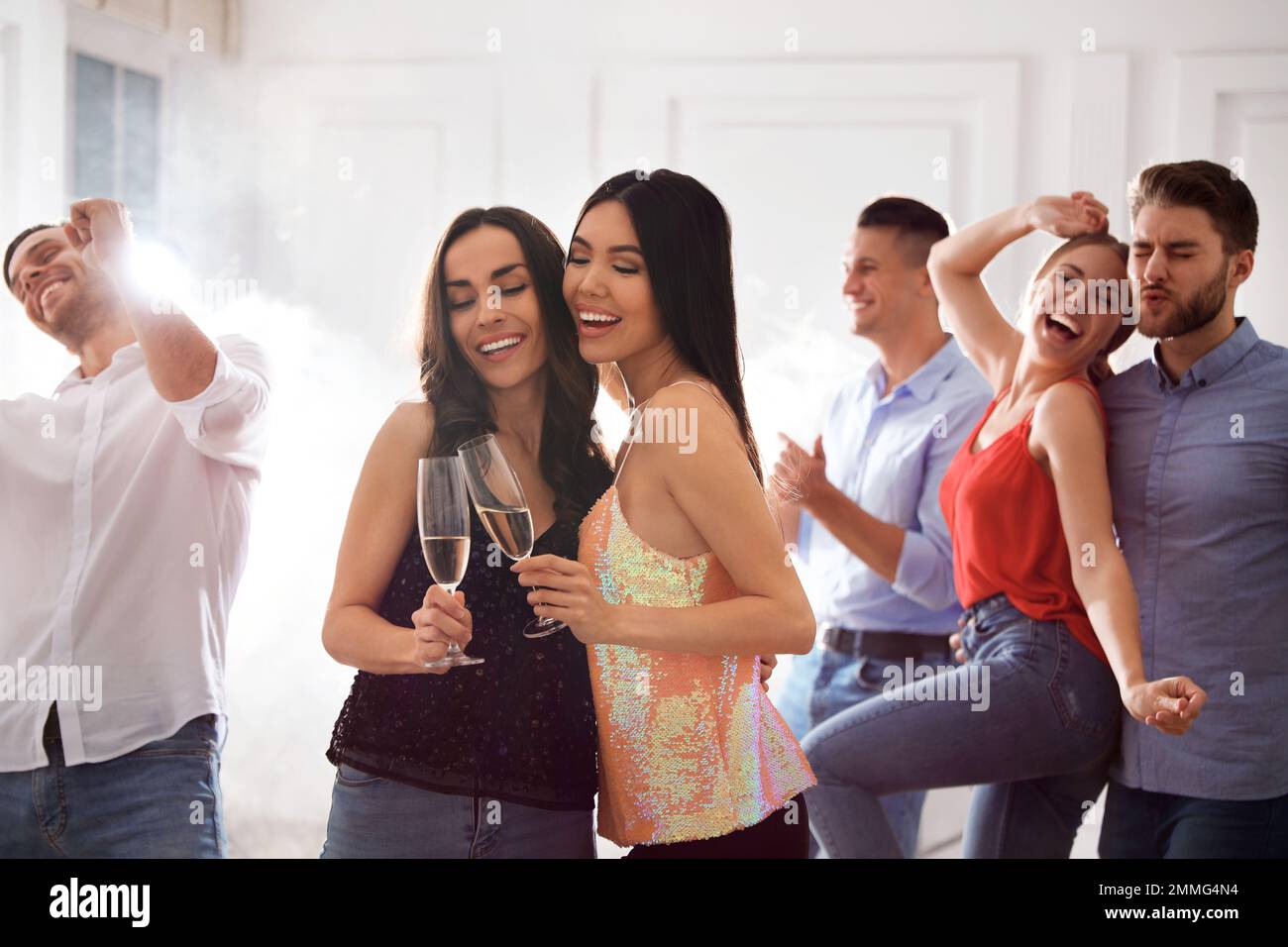 Couple of happy friends with champagne dancing at party Stock Photo - Alamy