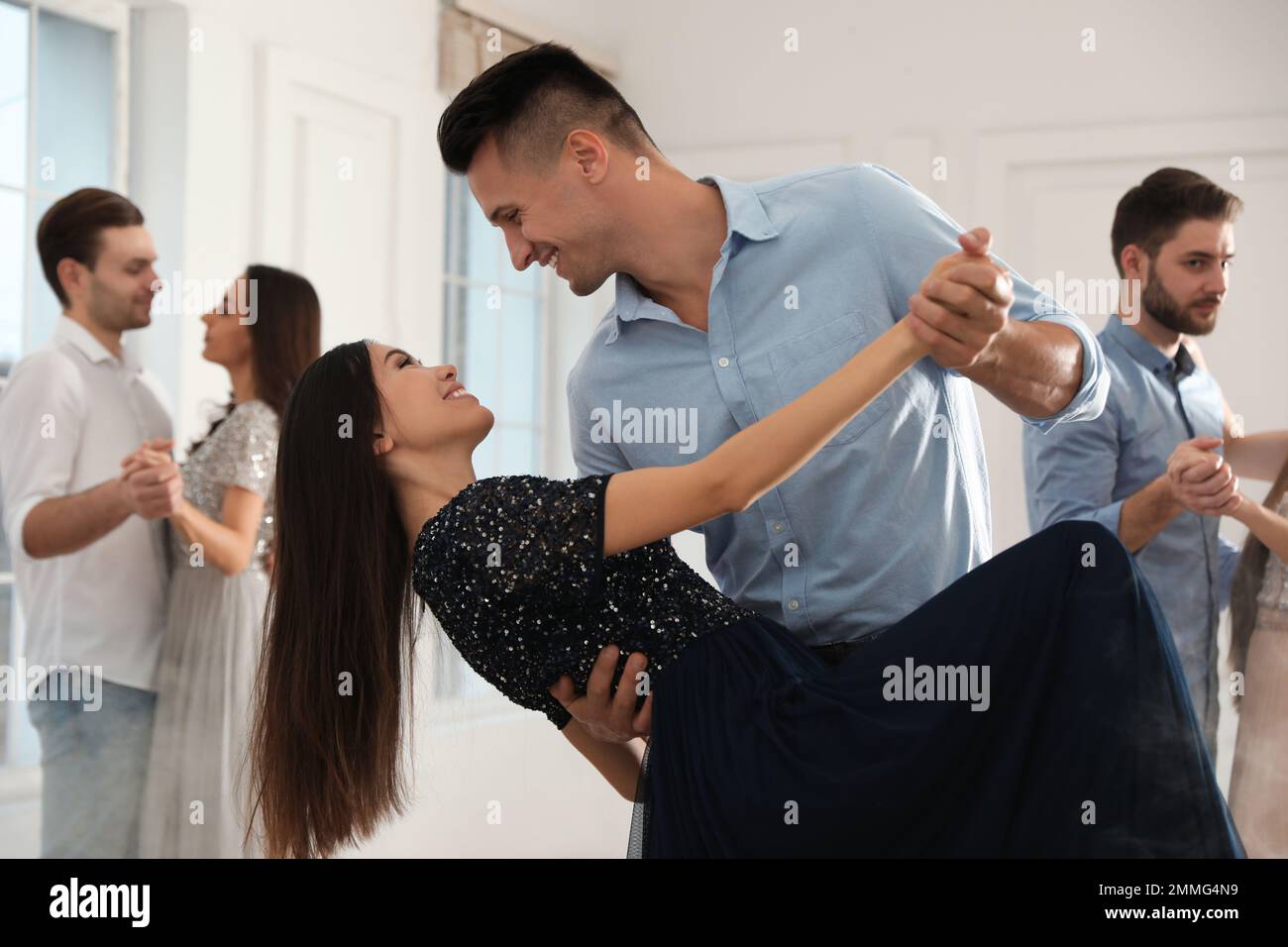 Lovely young couple dancing together at party Stock Photo - Alamy