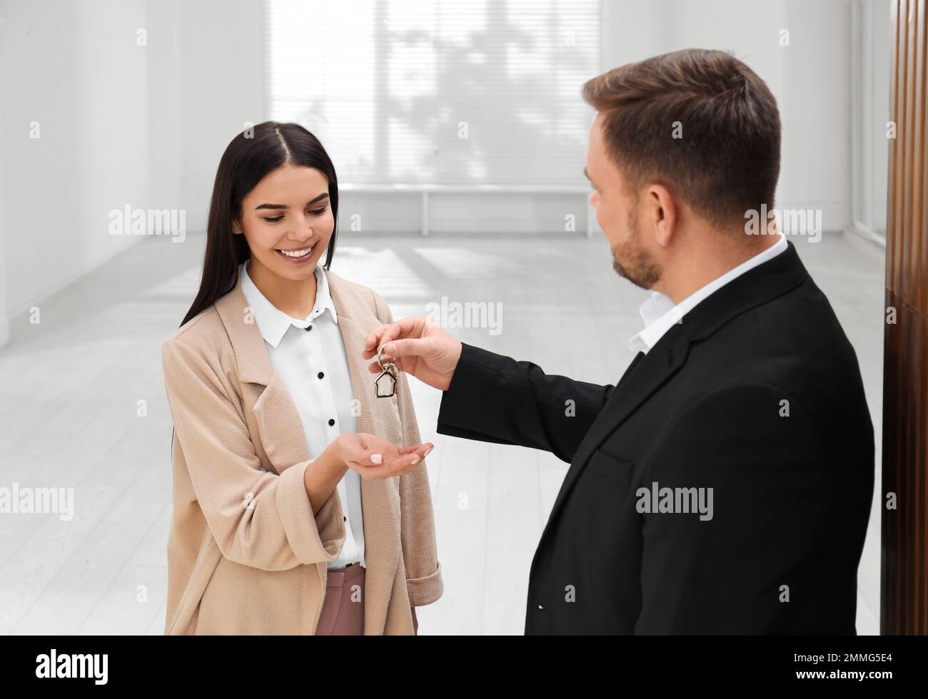Real estate agent giving key to client in new apartment Stock Photo - Alamy