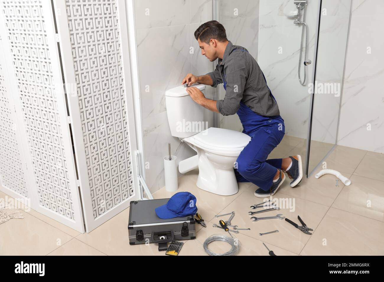 Professional plumber working with toilet bowl in bathroom Stock Photo ...