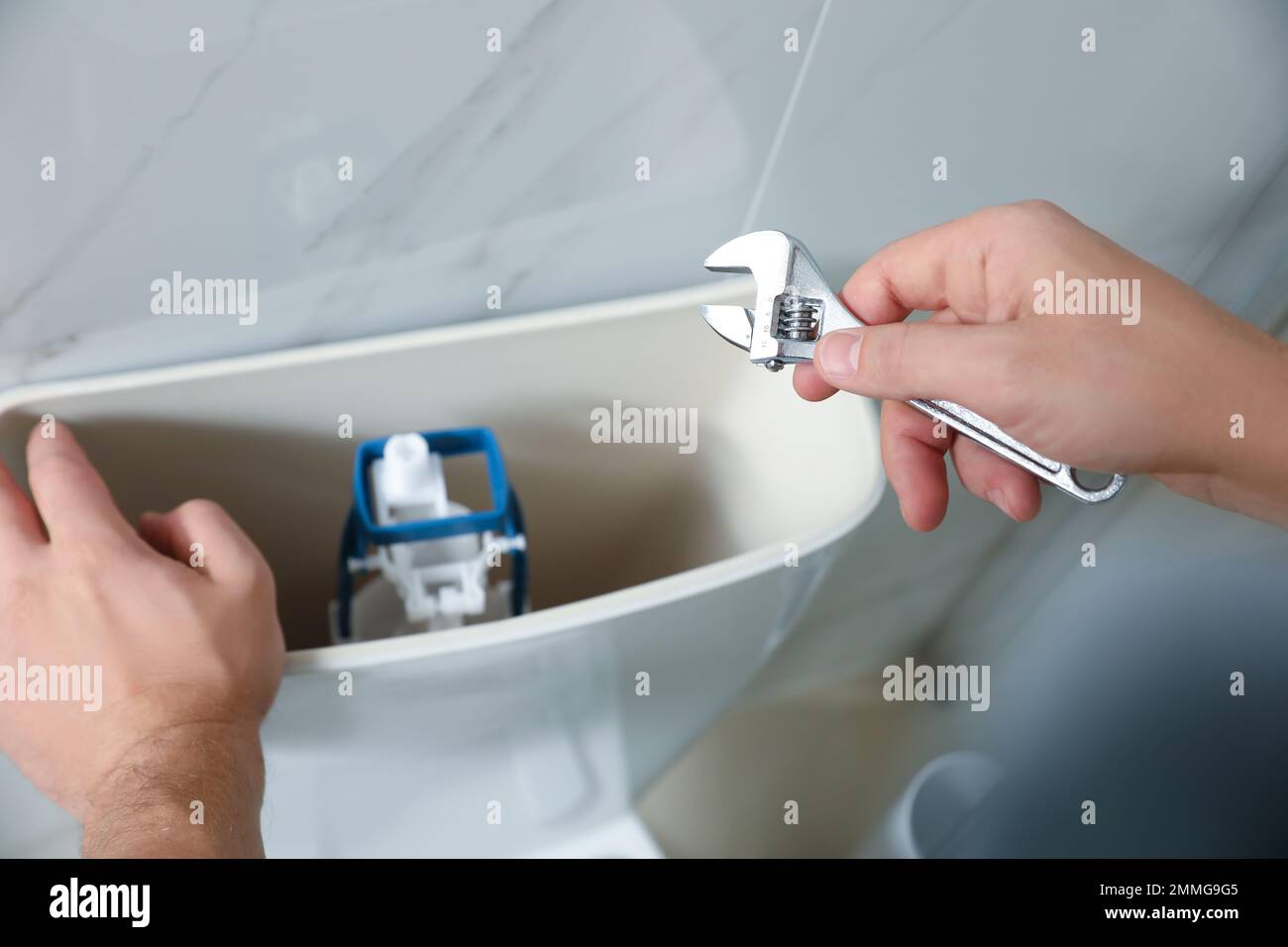 Hand fixing toilet cistern hi-res stock photography and images - Alamy