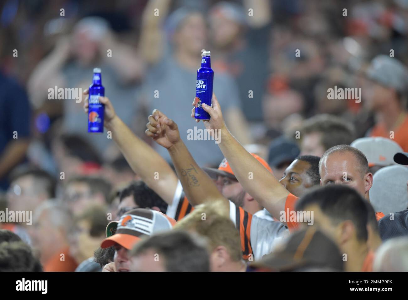 Fans hold up cans of beer during an NFL football game between the ...
