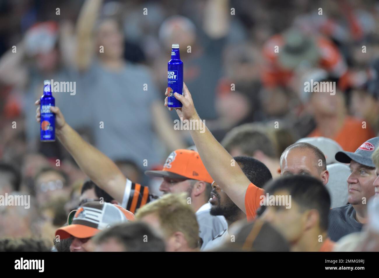 Fans hold up cans of beer during an NFL football game between the ...