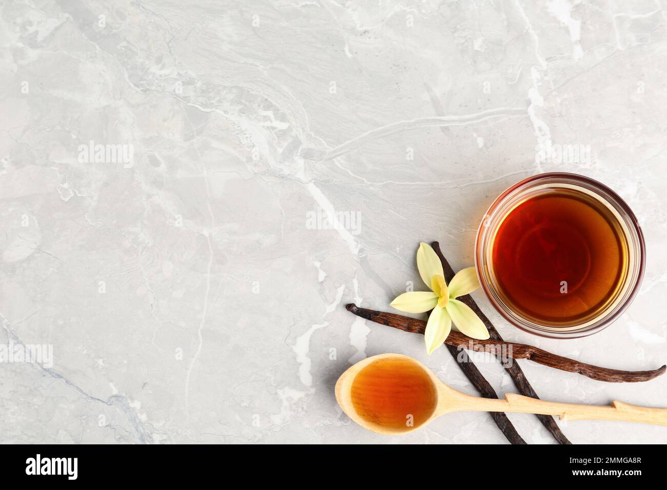 Flat lay composition with vanilla extract on light grey marble table ...