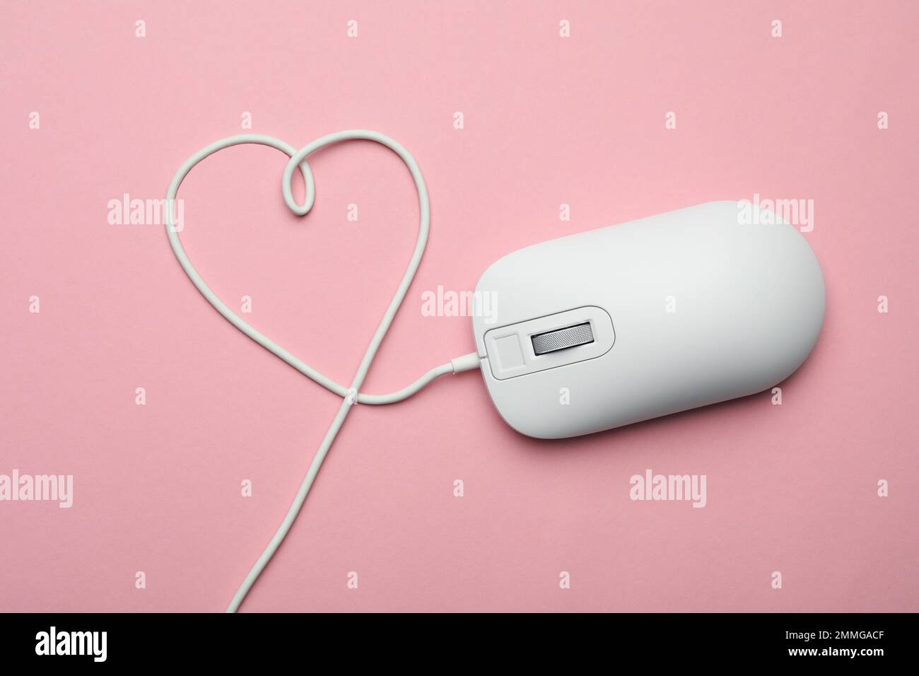 Computer mouse with heart shaped wire on pink background, top view Stock Photo - Alamy