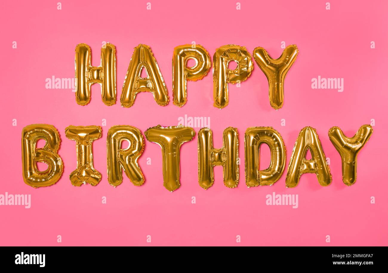 Phrase HAPPY BIRTHDAY made of foil balloon letters on pink background ...