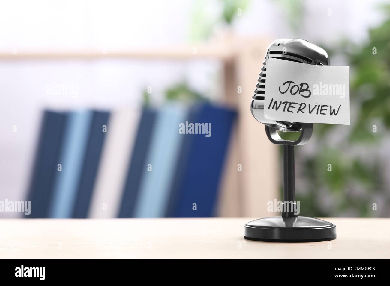 Retro microphone and reminder note with words JOB INTERVIEW on table ...