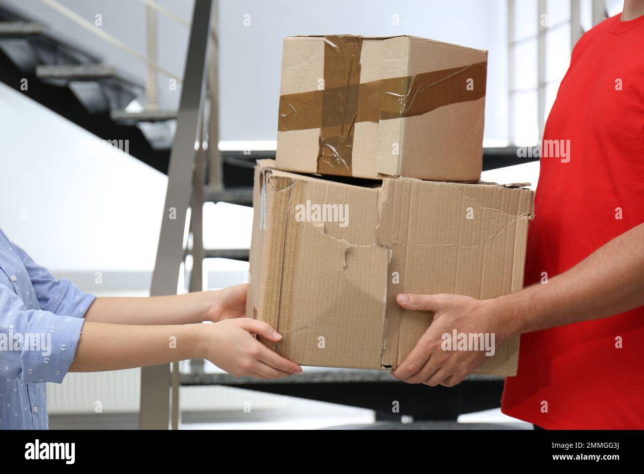 Courier giving damaged cardboard boxes to client indoors, closeup. Poor ...