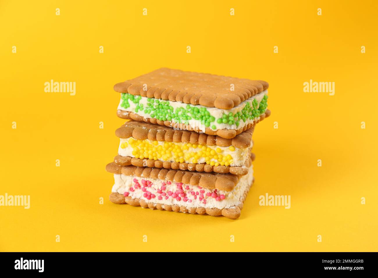 Sweet delicious ice cream cookie sandwiches on yellow background Stock ...