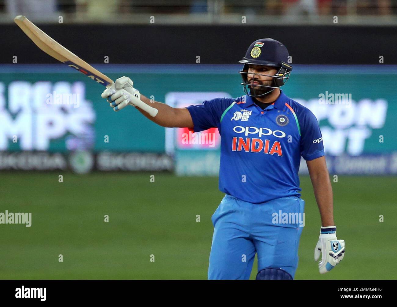 India's captain Rohit Sharma raises his bat to celebrate scoring fifty ...