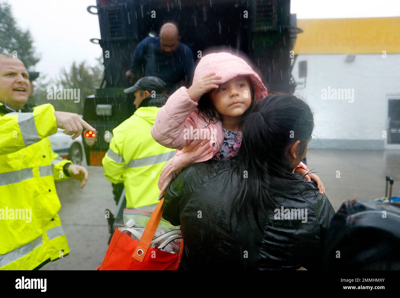 Joanna Faulkner carries her daughter Kayla, 3, out of a high water ...