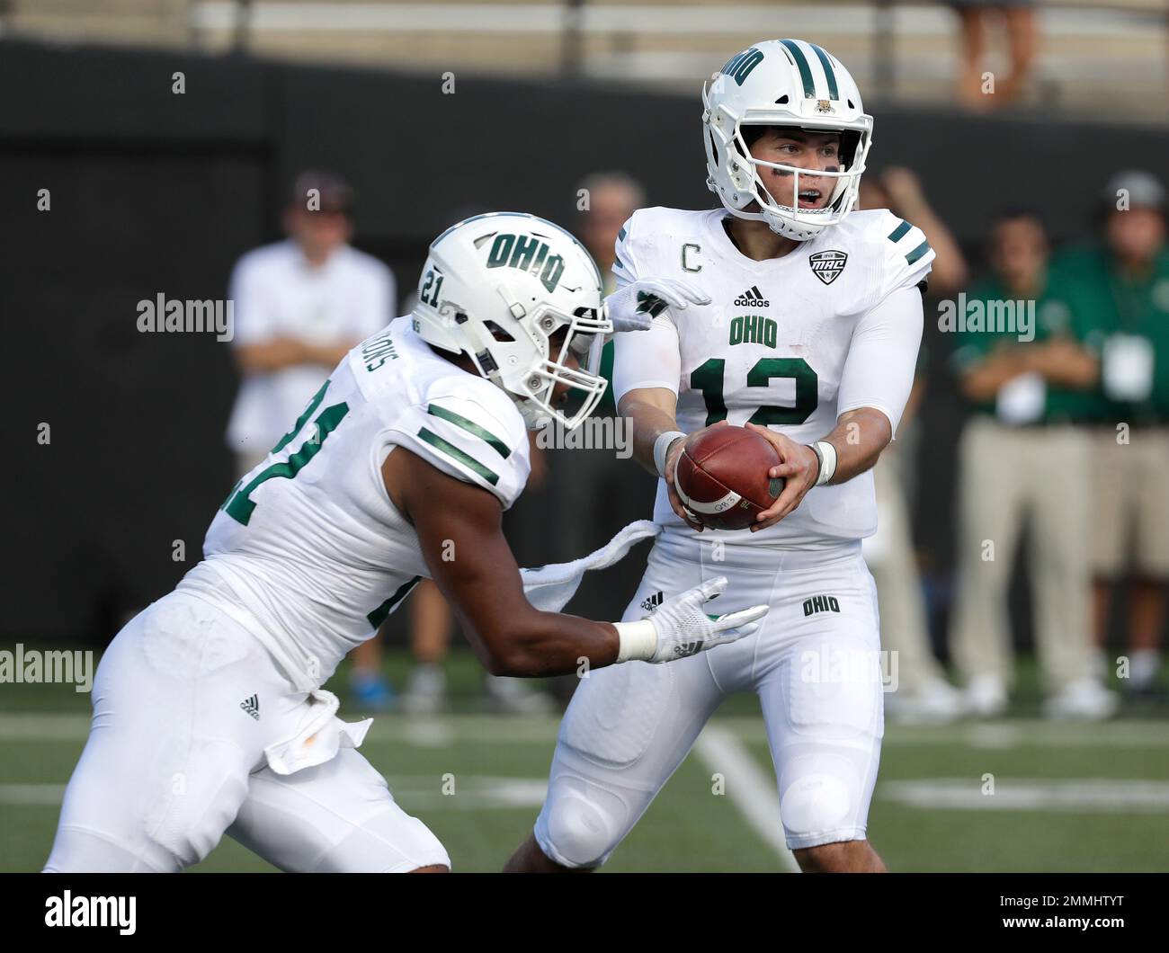 Ohio quarterback Nathan Rourke (12) hands the ball off to running back ...