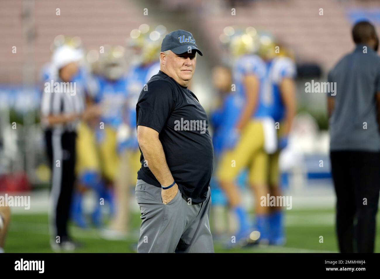 UCLA head coach Chip Kelly watches his team warm up before an NCAA ...