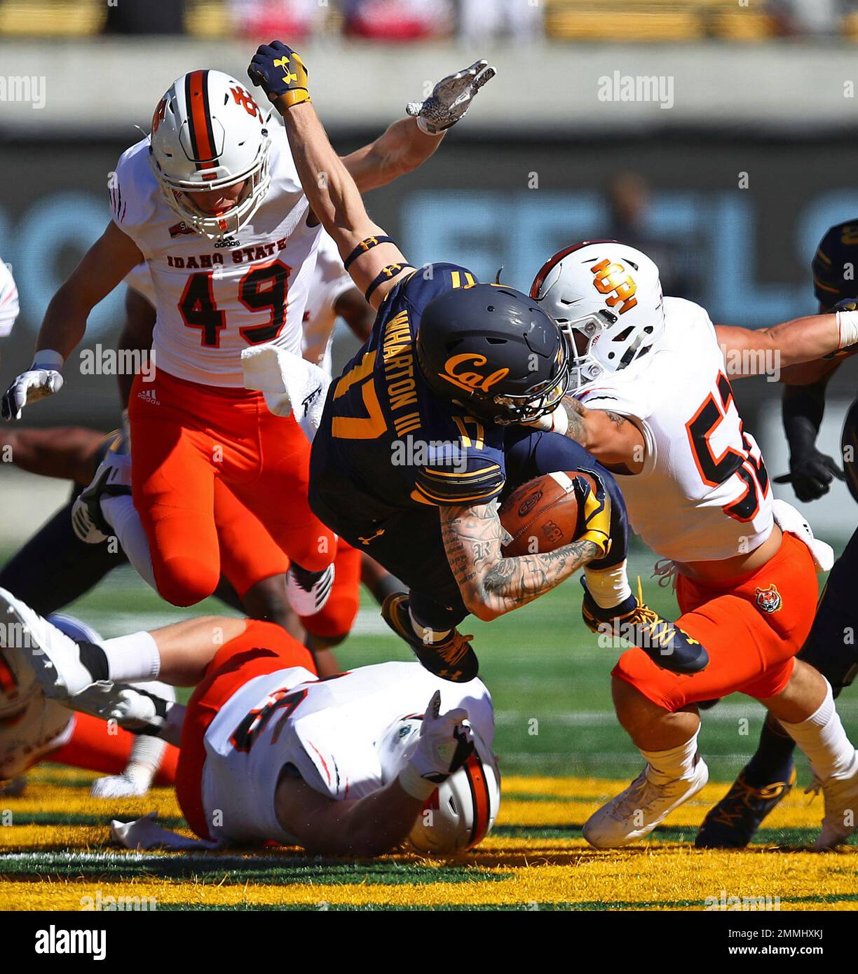 California wide receiver Vic Wharton III, center, is upended between ...
