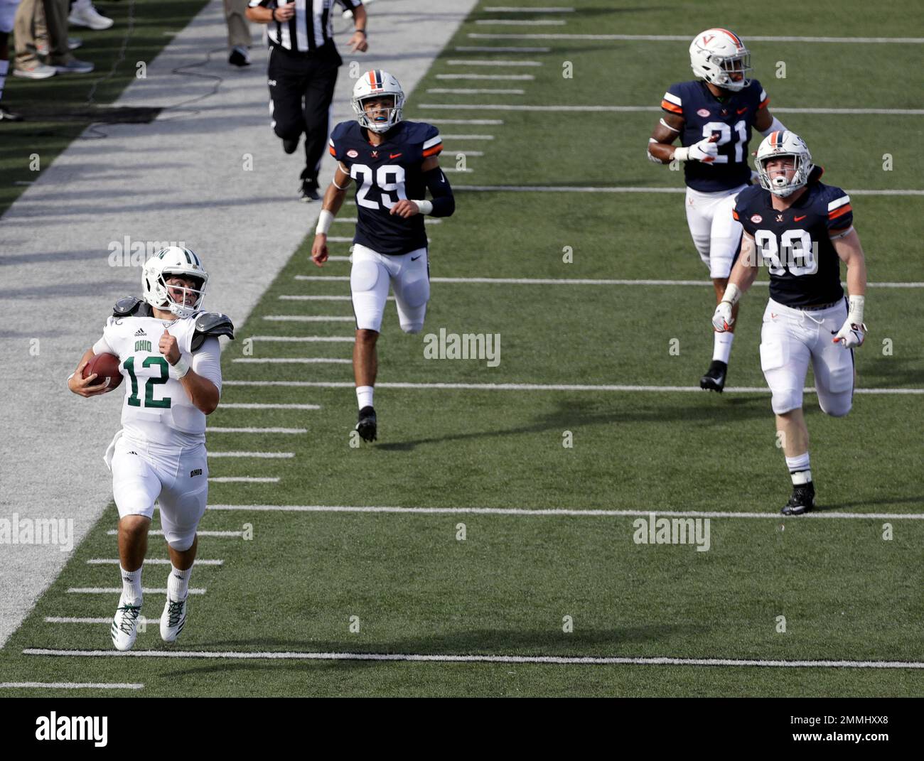 Ohio quarterback Nathan Rourke (12) leaves Virginia defenders Joey ...