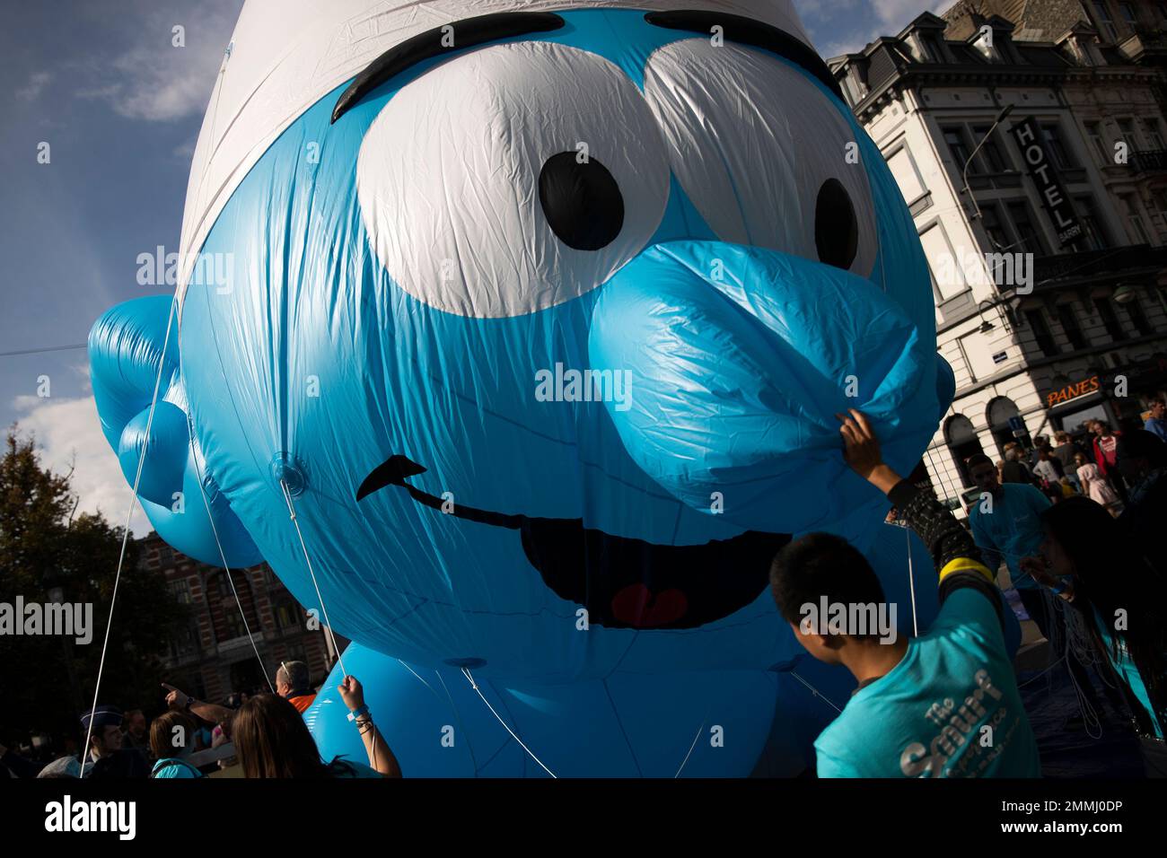 A volunteer grabs a giant inflated balloon in the shape of the comic ...