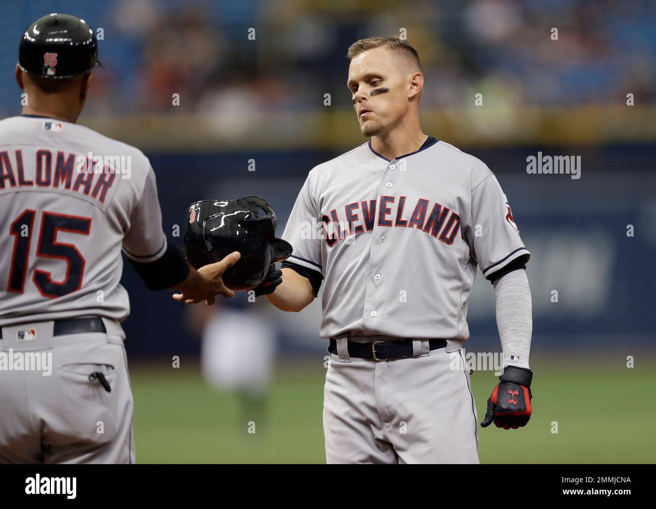 Cleveland Indians' Brandon Guyer, right, hands his helmet to first base ...
