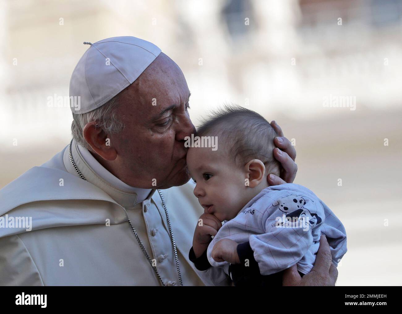 Pope Francis kisses a baby as he arrives in St. Peter's Square at the ...