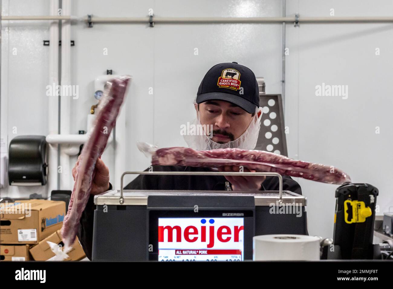 Macomb Twp., Michigan - A worker weighs cuts of meat at a Meijer ...