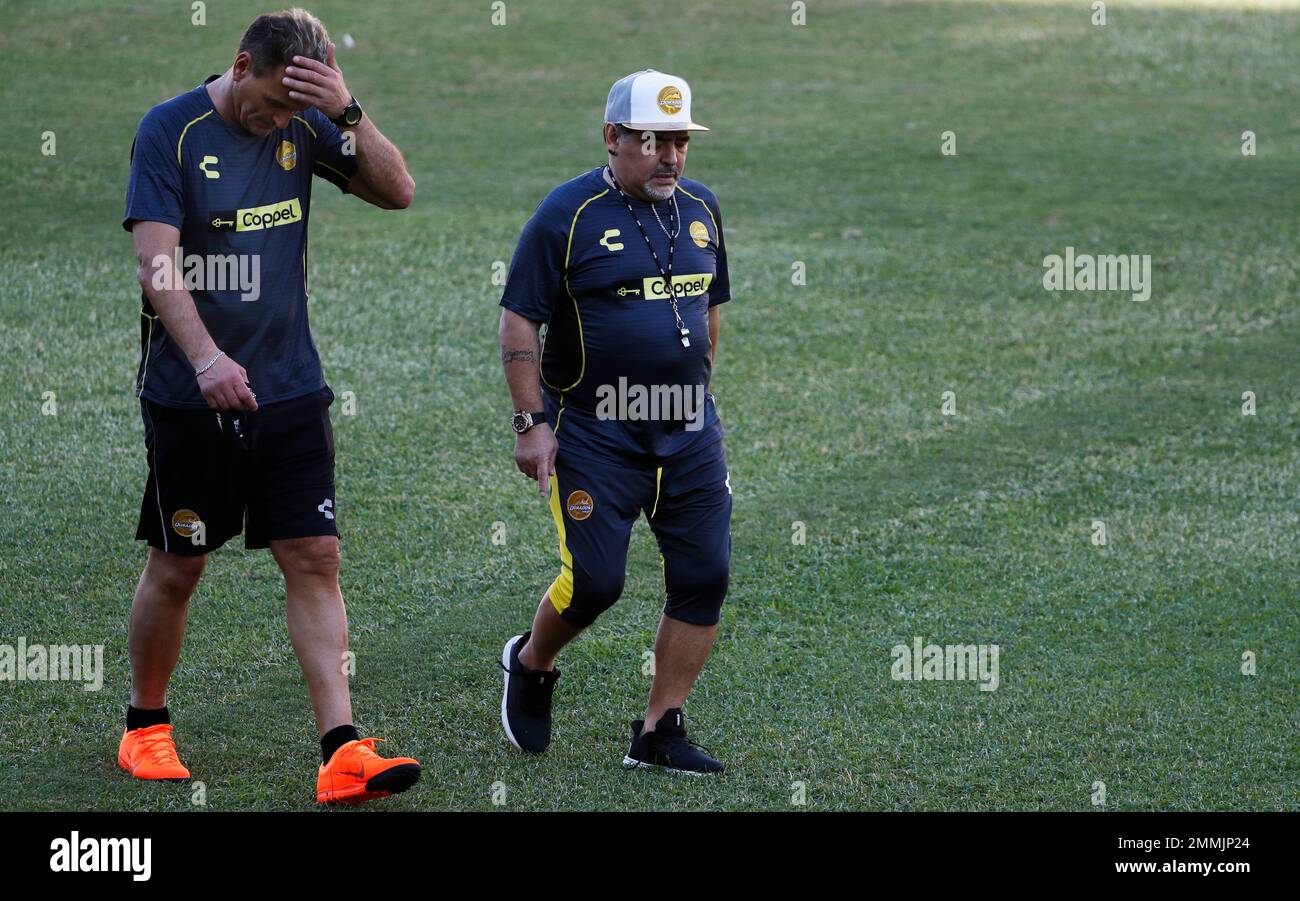 Former soccer great Diego Maradona and Luis Islas walk on the pitch at ...
