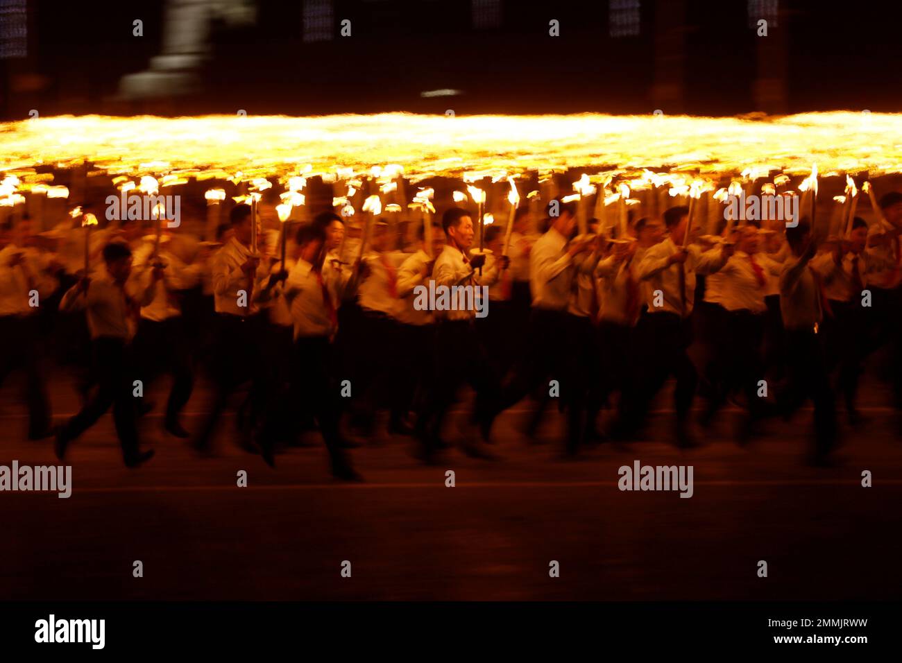 North Korean youths holding torches march during the torch light march ...