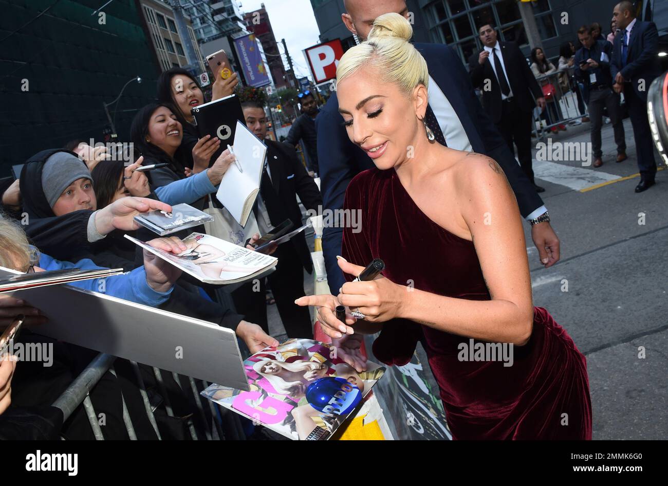 Lady Gaga signs autographs as she attends the press conference for "A ...