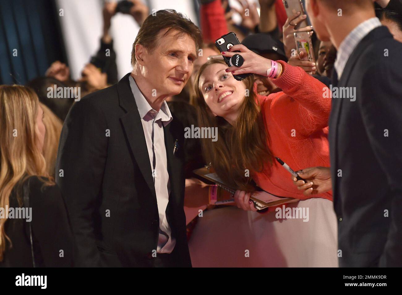 Liam Neeson takes a photo with a fan as he attends the premiere for ...