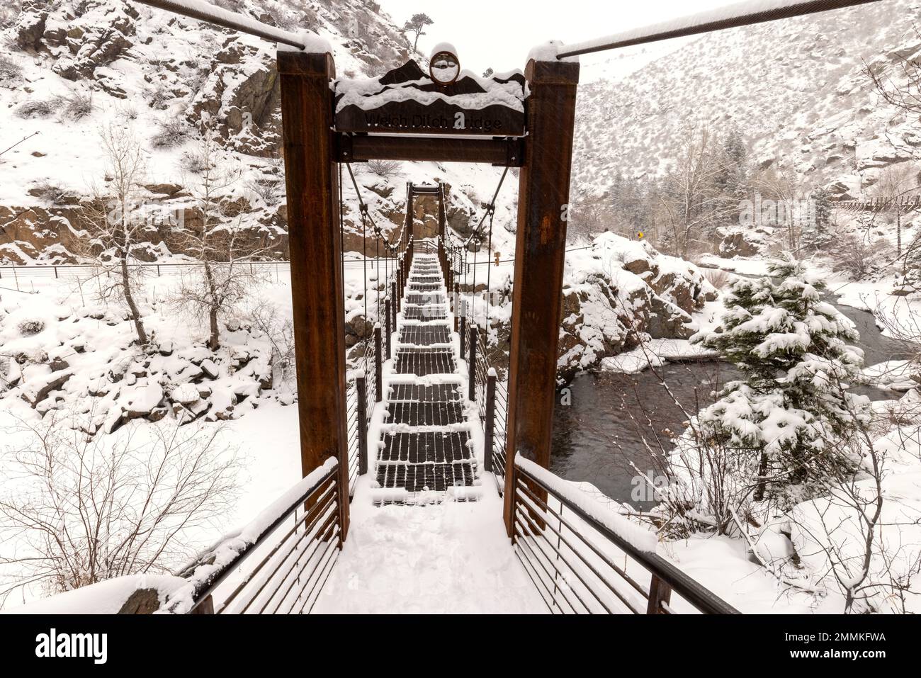 Snow-covered suspension bridge on Welch Ditch Trail in Clear Creek ...