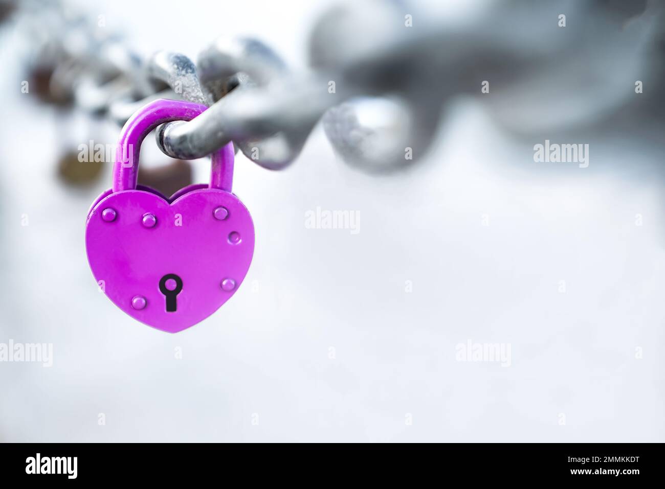 Pink heart shaped lock hangs from bridge chain, wedding custom is ...