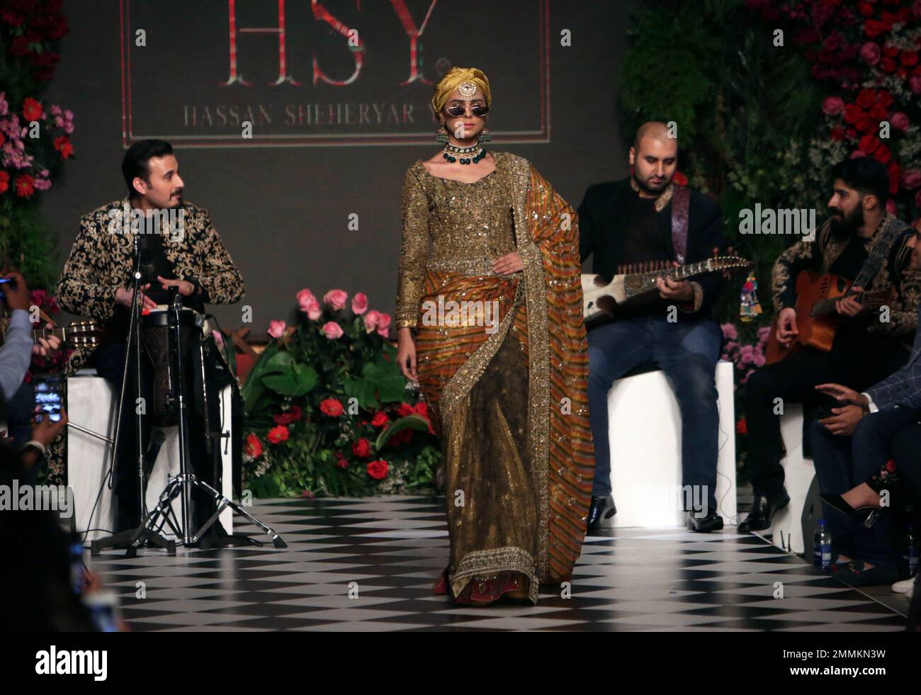 A model presents traditional dress designed by HSY during a fashion ...