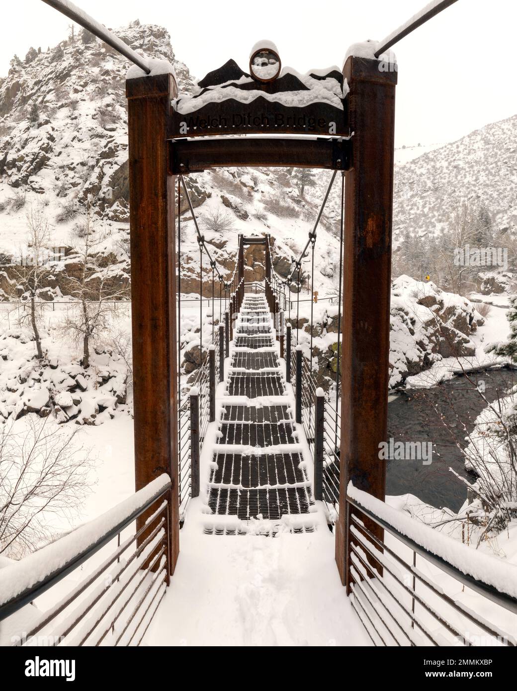 Snow-covered suspension bridge on Welch Ditch Trail in Clear Creek ...