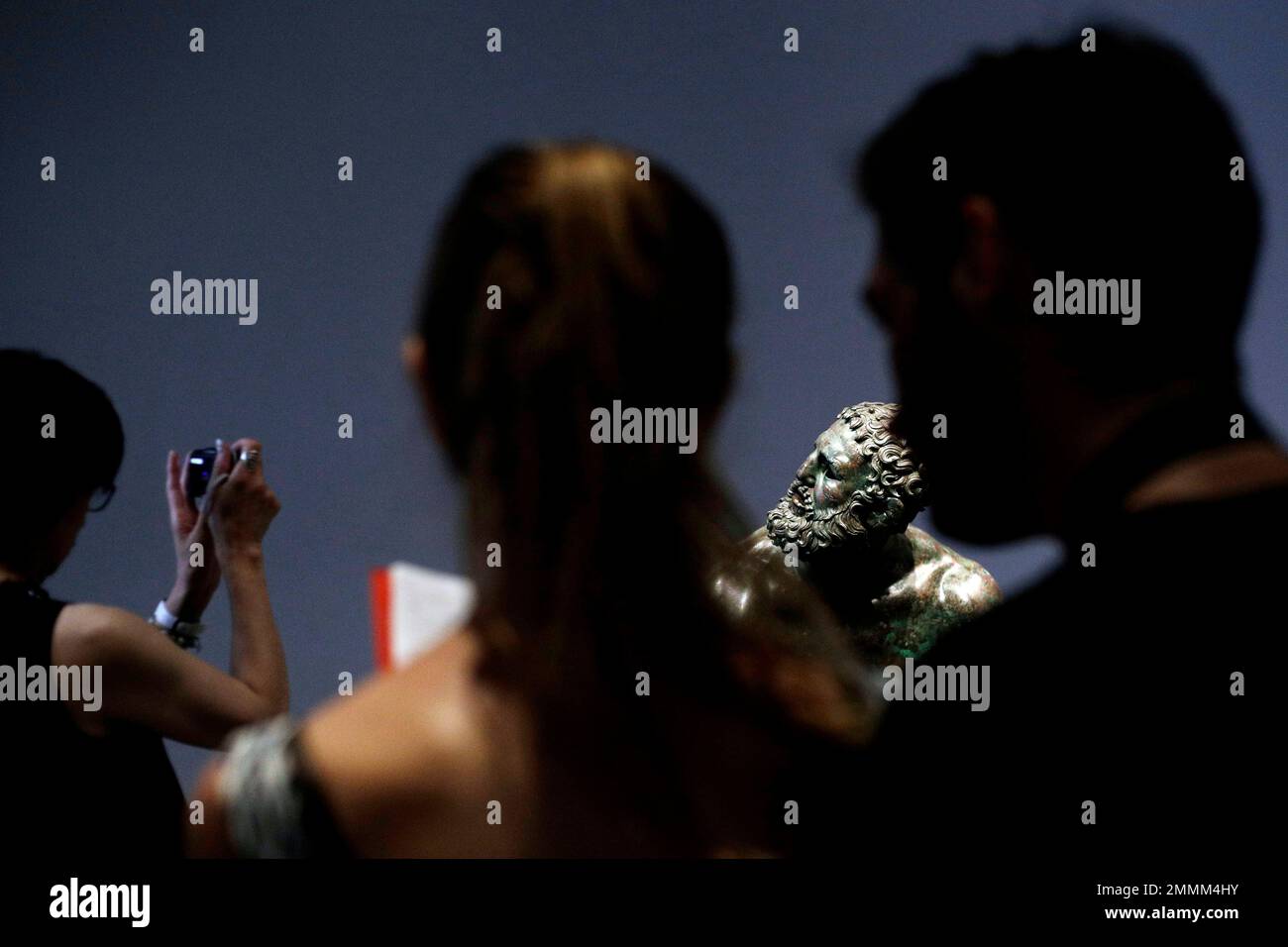 Tourists admire the bronze statue of the Boxer at Rest from the the ...