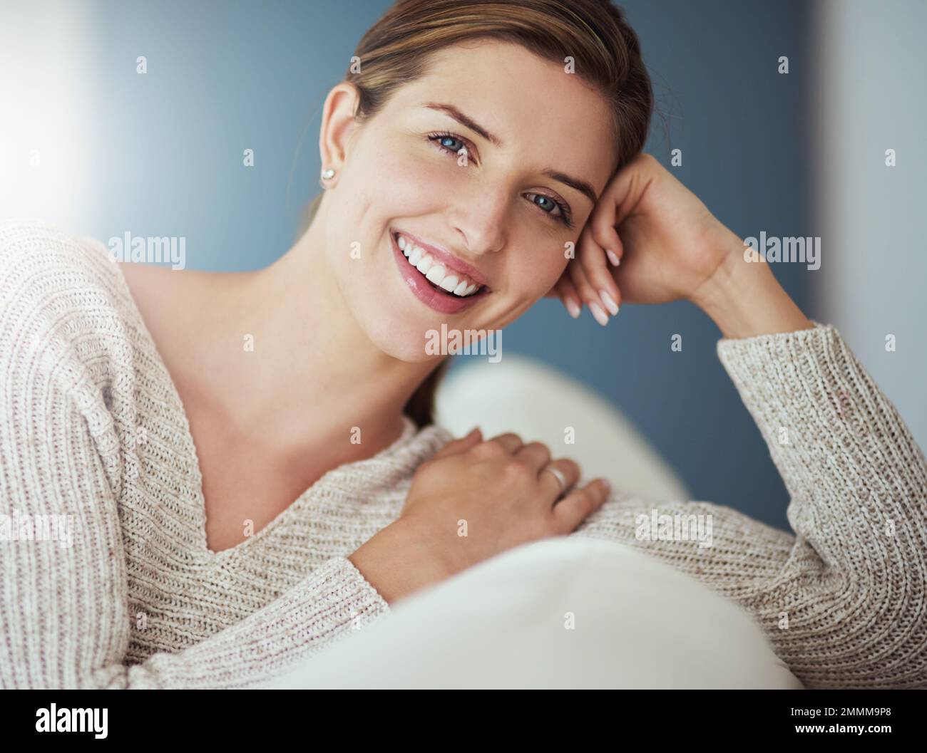 Take some time to relax and just be. a young woman relaxing on her sofa ...