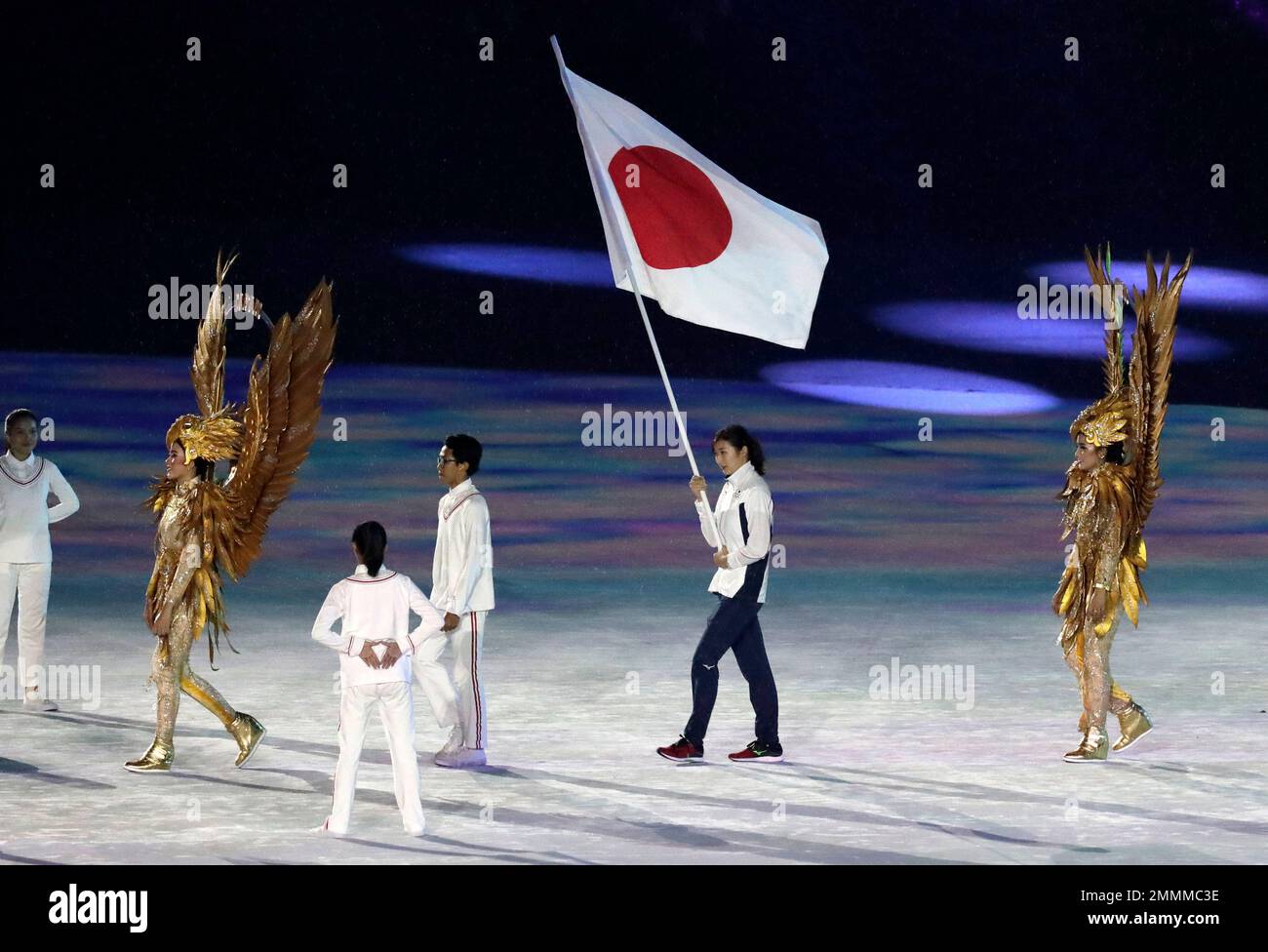 A Japanese athlete carries her nation's flag into the closing ceremony ...