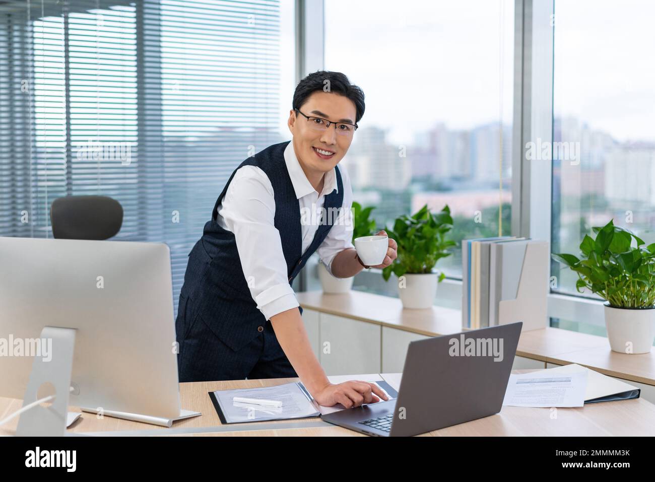Business a man standing over a desk hi-res stock photography and images ...
