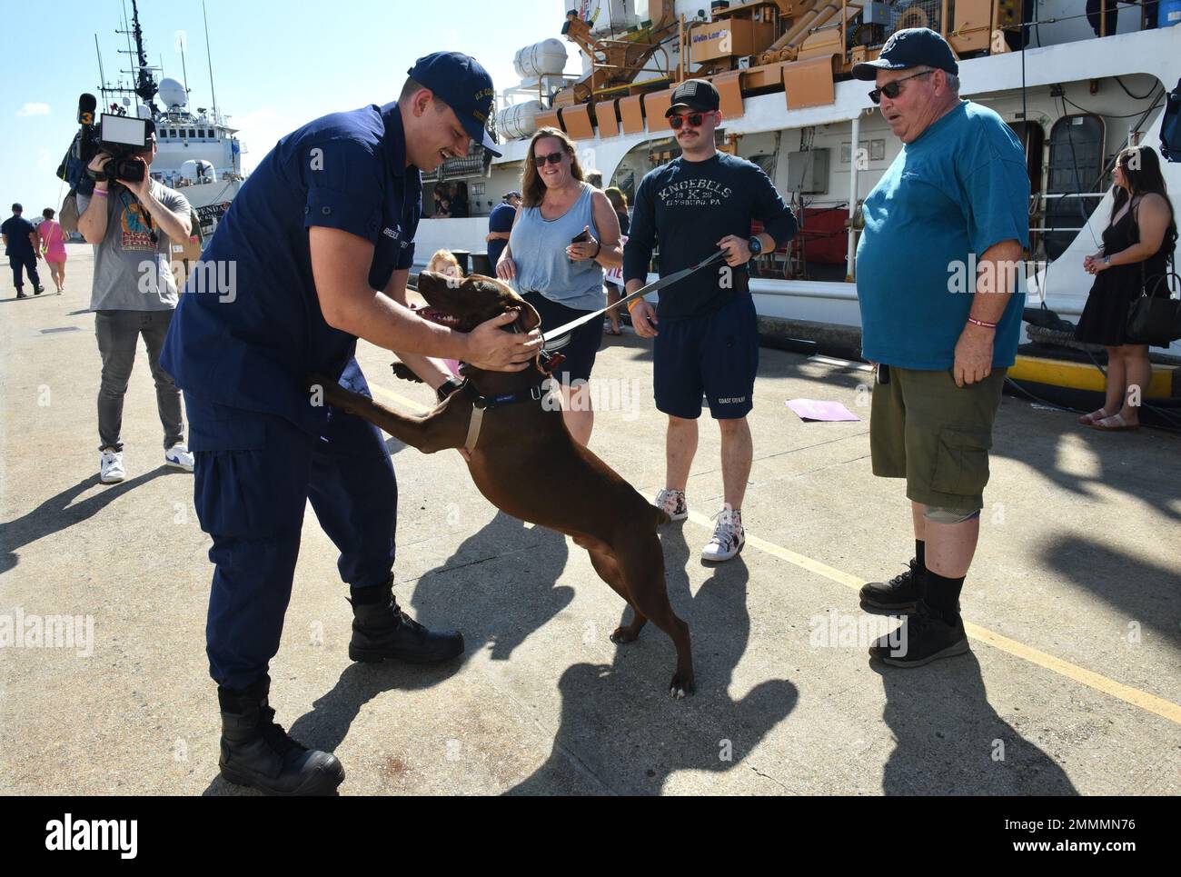 A USCGC Legare (WMEC 912) crew member greets his four-legged friend at ...