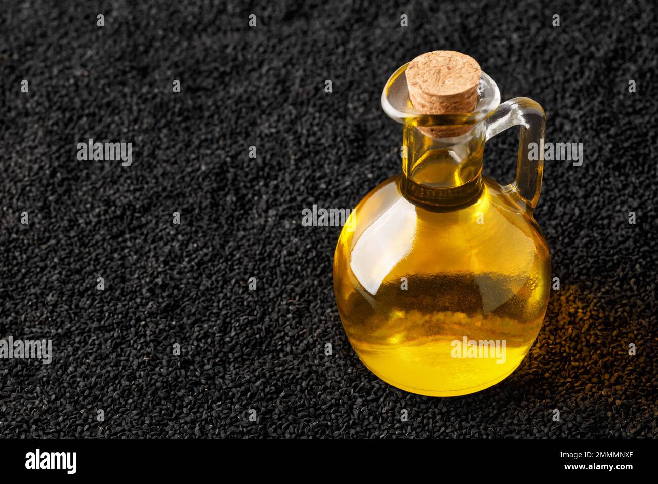 black cumin oil in bottle and scattered seeds as background Stock Photo ...