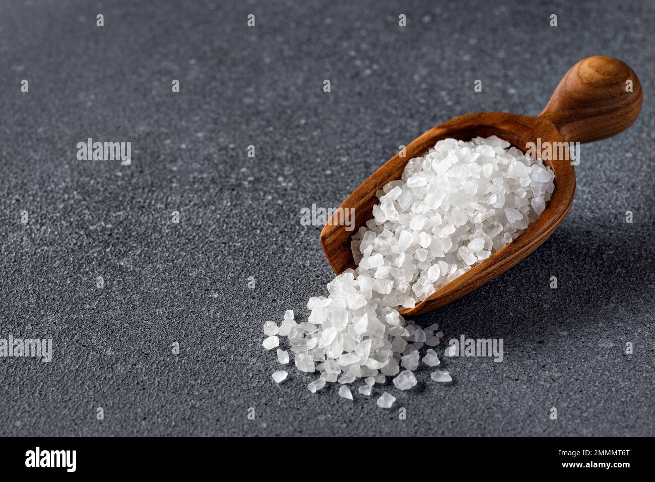 sea salt in wooden scoop on grey background Stock Photo - Alamy