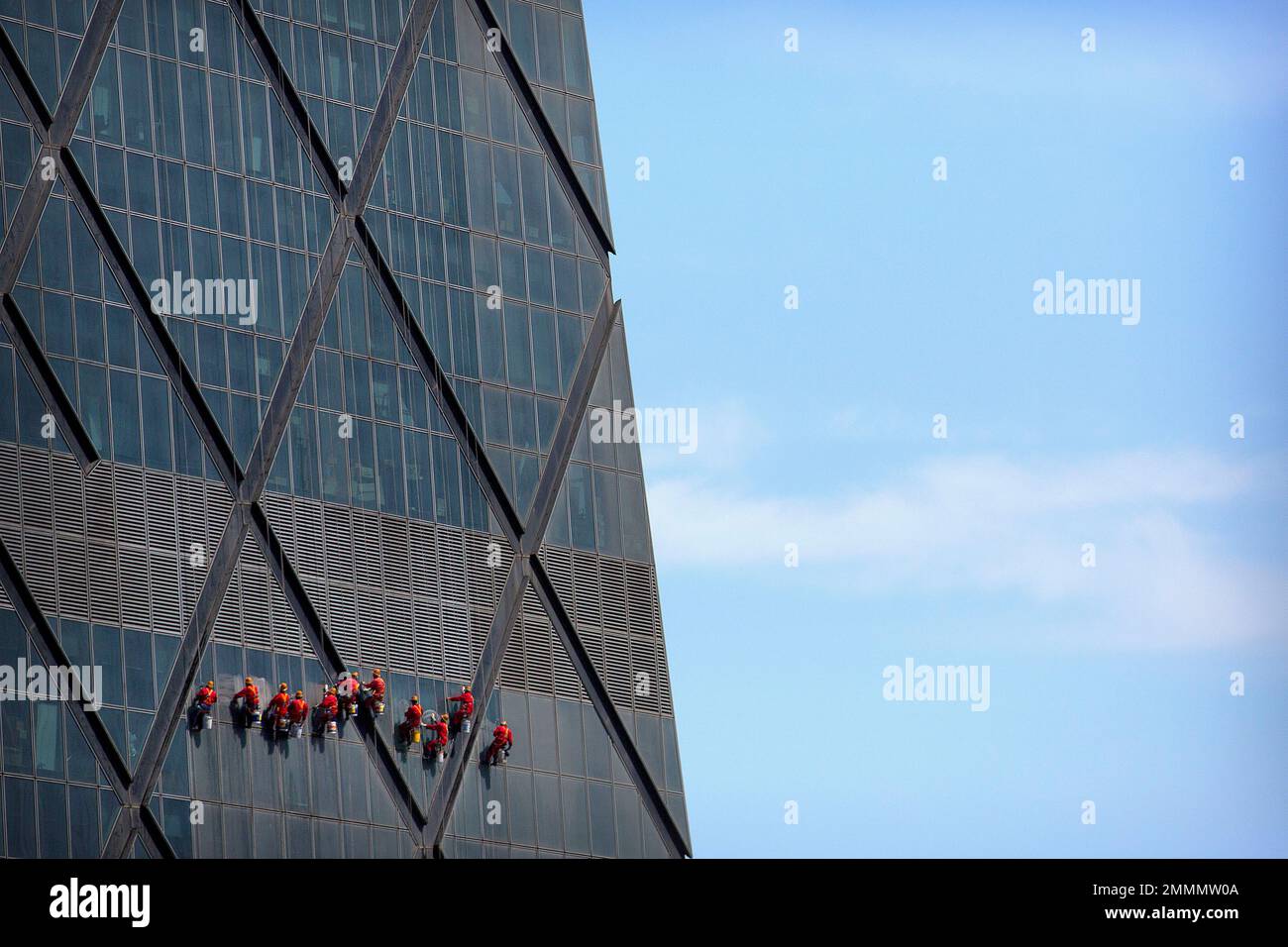 Window washers dangle from ropes as they clean the facade of the China ...
